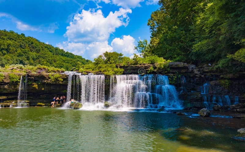Group of People Enjoying a Break at the Base of a Rushing Waterfall ...