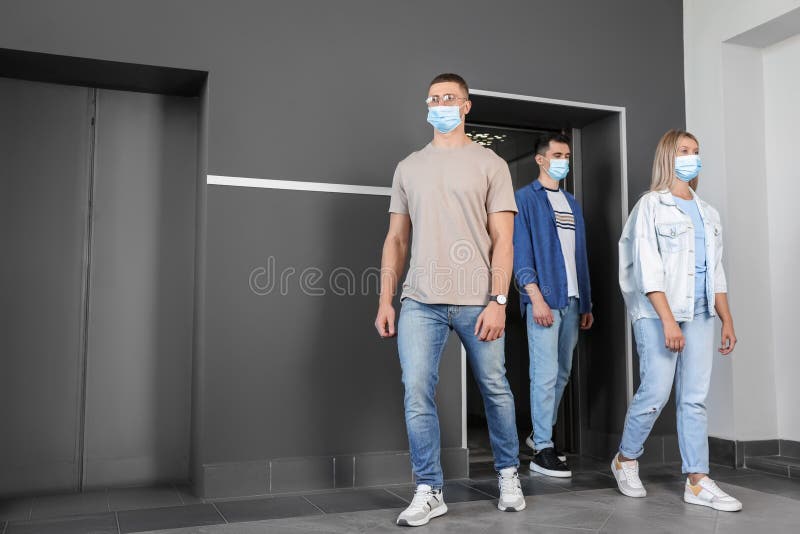 Group of People in Face Masks Walking Out from Elevator. Protective ...