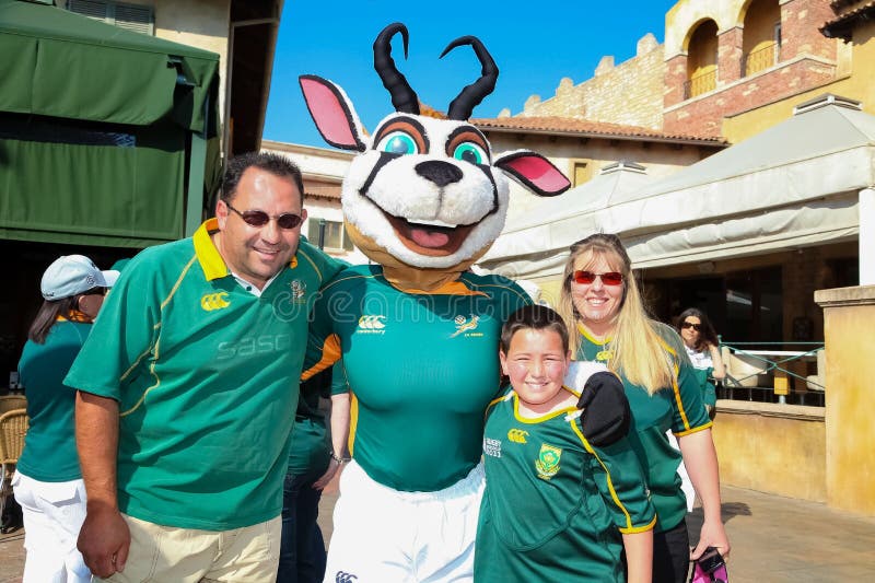 Group of People in Green Jerseys Posing with a Sport Team Mascot ...