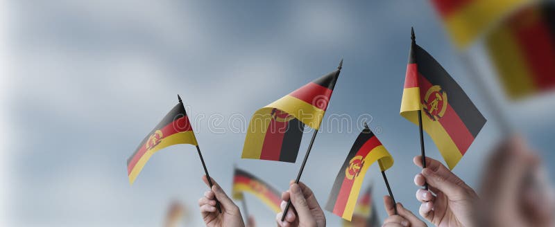 A Group of People Holding Small Flags of the DDR in Their Hands Stock ...
