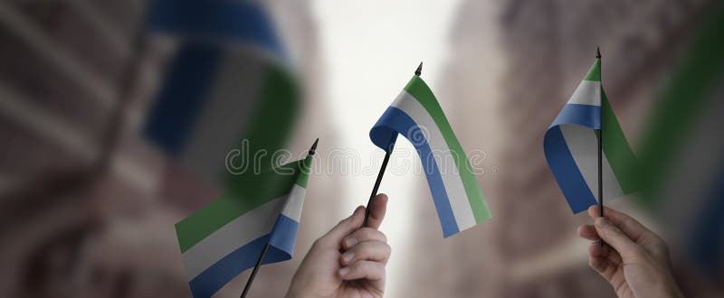 A Group of People Holding Small Flags of the Sierra Leone in Their ...