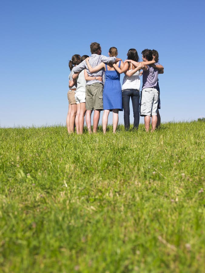Group of People in Huddle in Field Stock Photo - Image of lawn, horizon ...