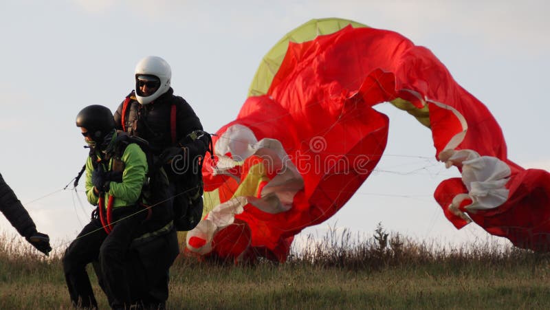 Group of People Landing after Paragliding with the Cloudy Sky in the ...