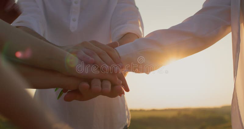 A Group of People Put Their Palms on Top of One Another and Raise Them ...