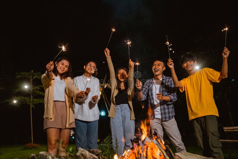 A Group of People Raise Their Fireworks and Smiling Stock Photo - Image ...