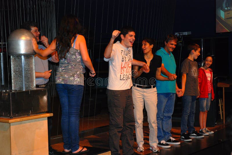 A Group of People Receive a Shock in an Electricity Demonstration ...