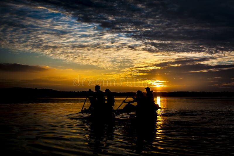 Group of Men Rowing Over the River at Sunset Stock Photo - Image of ...