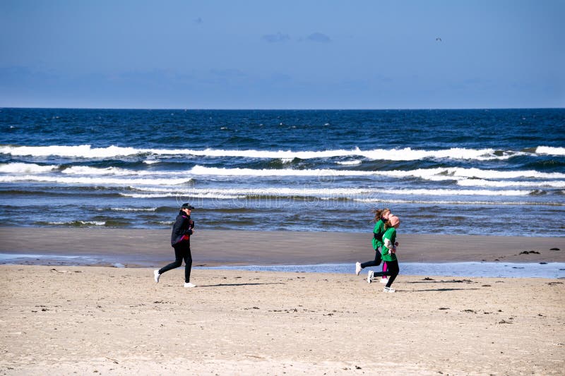 A Group of People Runs a Marathon on the Beach by the Sea Editorial ...