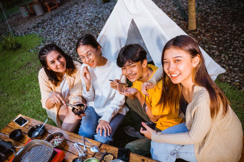 A Group of People Smiling Together while Eating Grilled Beef Stock ...