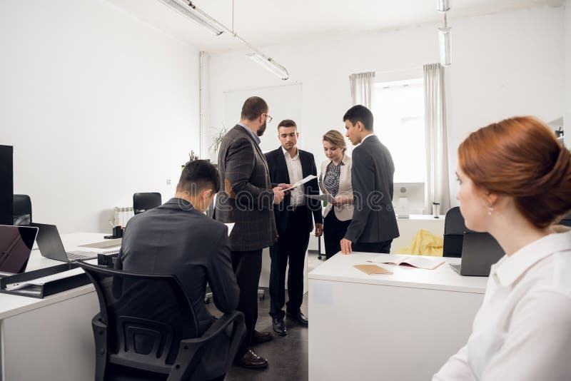 Group of People Stand with Documents and Discuss Them in the Office ...