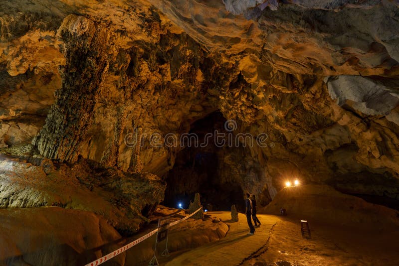 Group of People Stand Inside of a Cave at Night, Looking at Rocky ...