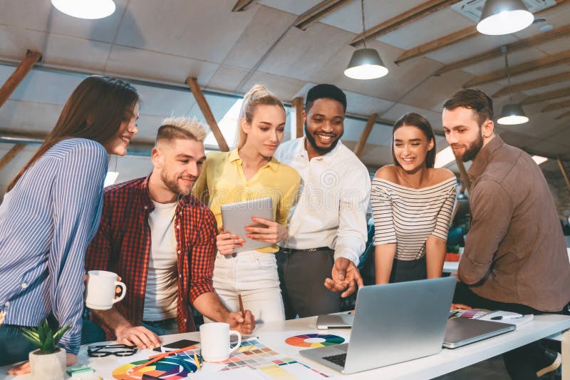 Group of People Standing Around Table with Laptop Stock Image - Image ...