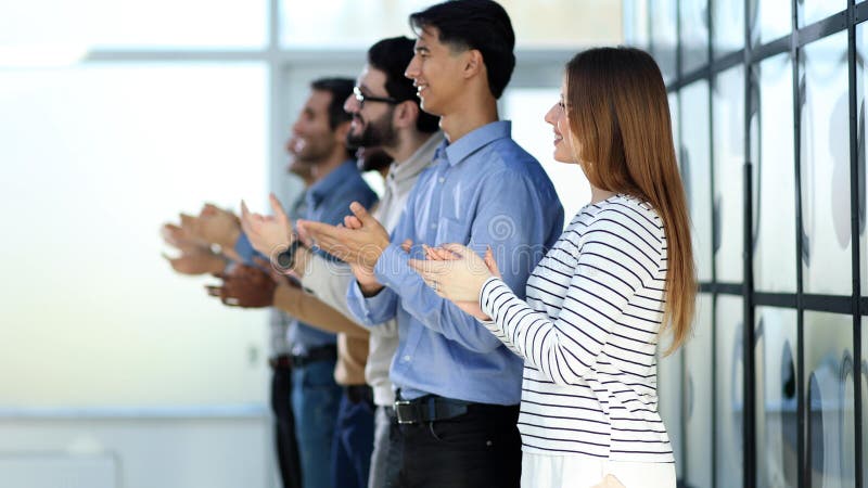 A Group of People Standing in a Row Clapping Their Hands Stock Photo ...