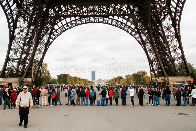 Group of People Under the Eiffel Tower with a Cloudy Sky in the ...