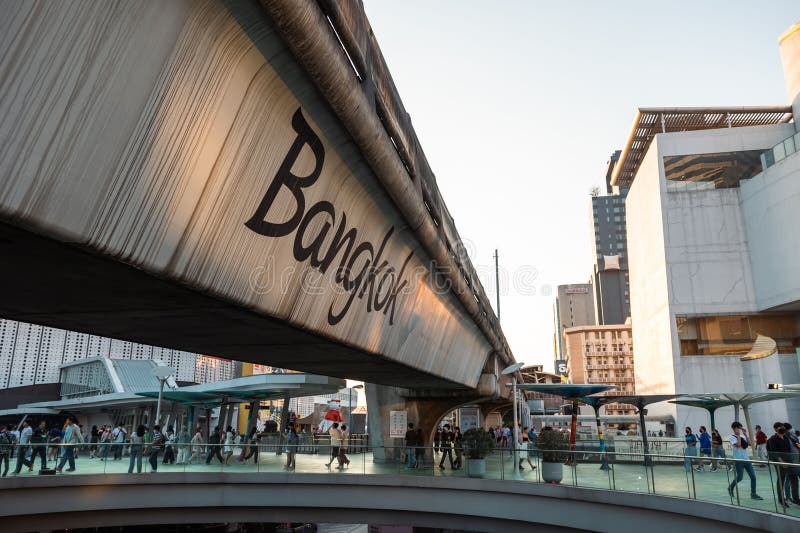 Group of People Walking Along an Elevated Walkway Situated Beneath a ...