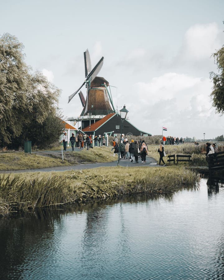 Group of People Walking Along a Path Toward a Picturesque Windmill on ...