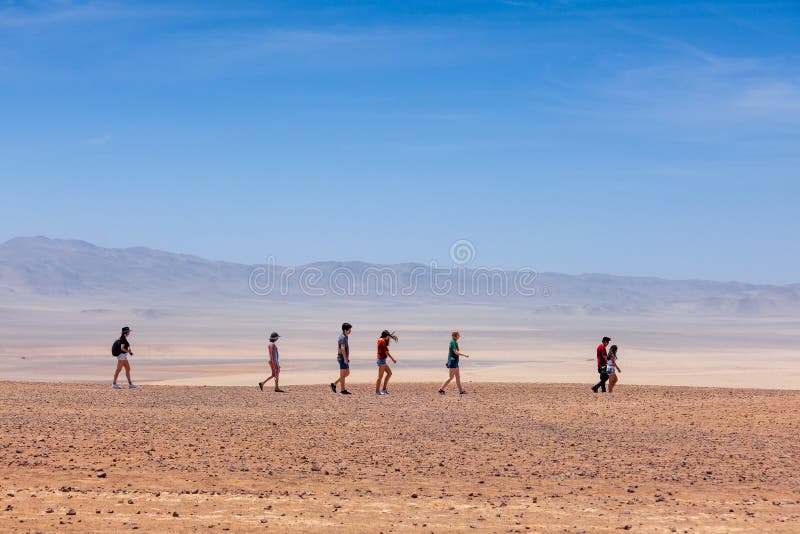 Desert. Group of People in the Distance Walk on Top of a Hill in the ...