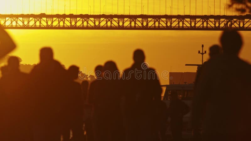 A Group of People are Walking Under a Bridge at Sunset Stock Footage ...