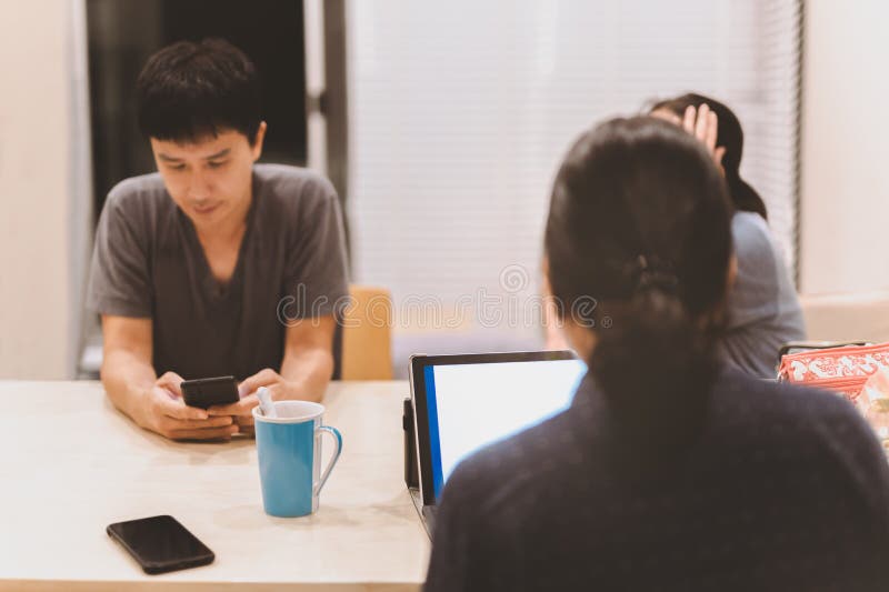 Group of People Work Late at Night Sitting at Kitchen Table Working on ...
