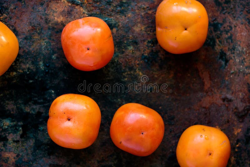 Group of Persimmons on Black Rustic Surface. Stock Image - Image of ...