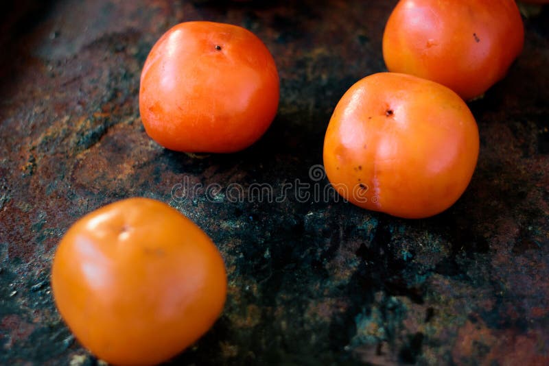Group of Persimmons on Black Rustic Surface. Stock Photo - Image of ...