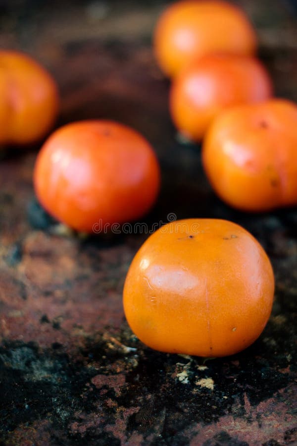 Group of Persimmons on Black Rustic Surface. Stock Image - Image of ...