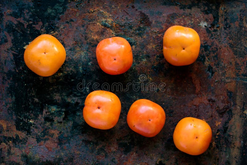 Group of Persimmons on Black Rustic Surface. Stock Image - Image of ...