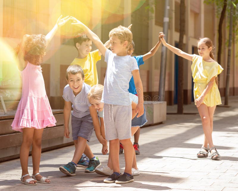 Group of Positive Schoolchildren Holding Hands Up and Playing Stock ... Group of Positive Schoolchildren Holding Hands Up and Playing Stock ...