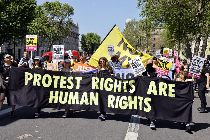 Group of Protestors Walking Down a Street, Holding a "Protest Rights ...