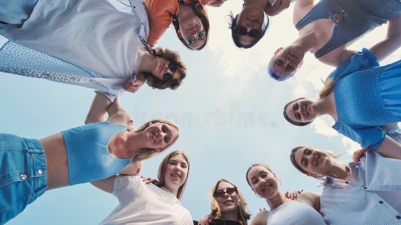Group of Recent Graduates Forming a Circle, Linking Arms, and Waving ...