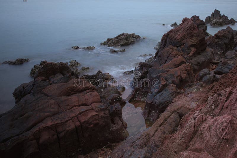 Red rocks on the coast stock image. Image of pebble - 380865311