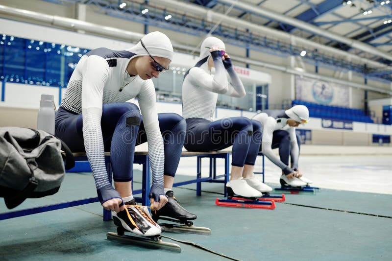 Group of Restful Speed Skaters Tying Shoelaces on Skates at Break Stock ...