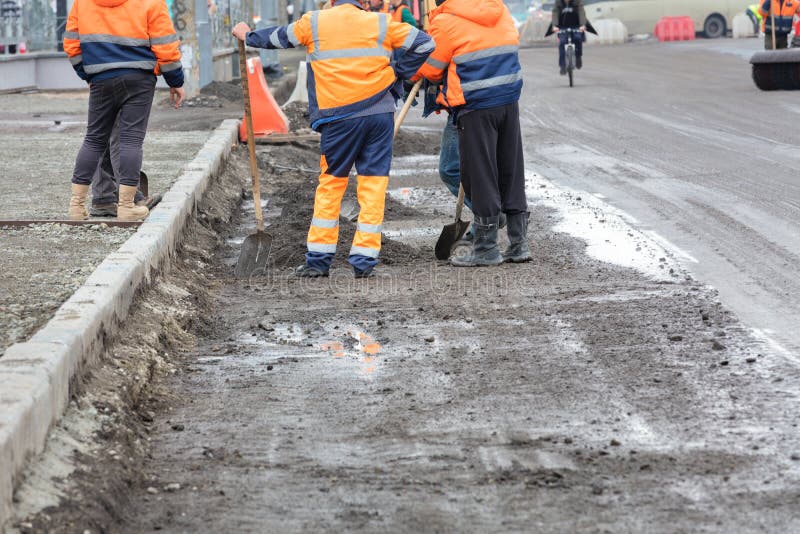 A Group of Road Workers Install Road Curbs Along the Roadway Stock ...