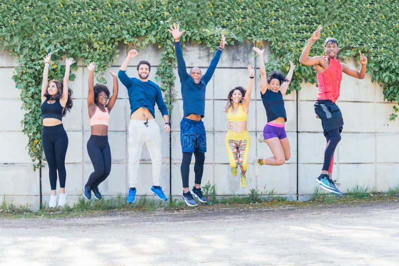 Group of Runners Jumping at the Same Time in a Park. Stock Photo ...