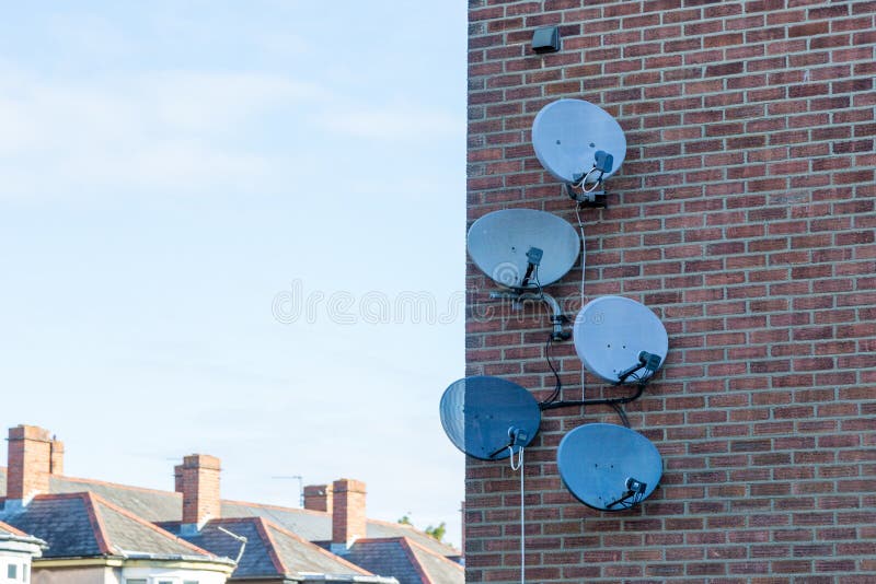 A Group of Satellite Dishes on the Side of a Brick Building Stock Photo ...