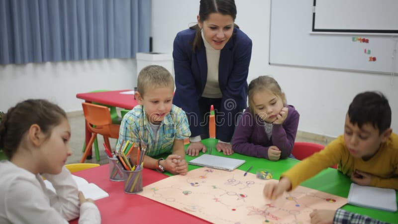 Happy Kids and Female Teacher Playing Together Educational Board Game ... Happy Kids and Female Teacher Playing Together Educational Board Game ...