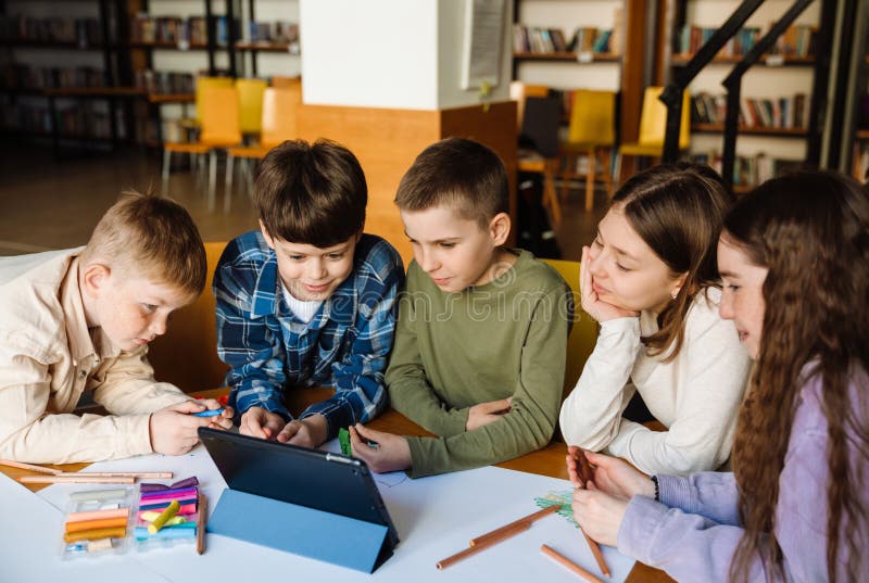 Group of Kids Watching Something on Tablet while Sitting in Library ...