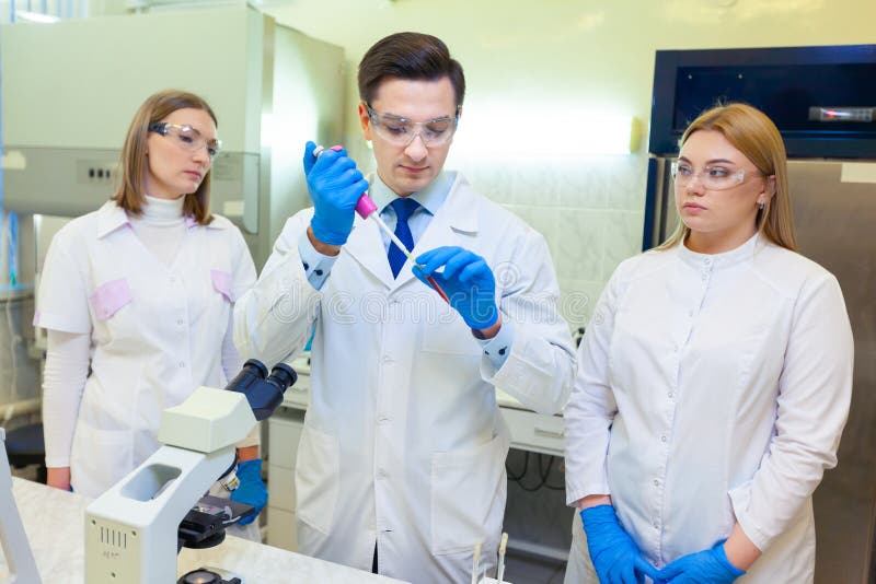 A Group of Scientists Conducts Research in a Scientific Laboratory ... A Group of Scientists Conducts Research in a Scientific Laboratory ...