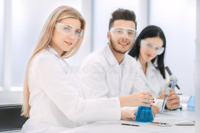 Group of Scientists Discuss the Liquid in the Flask. Stock Photo ...
