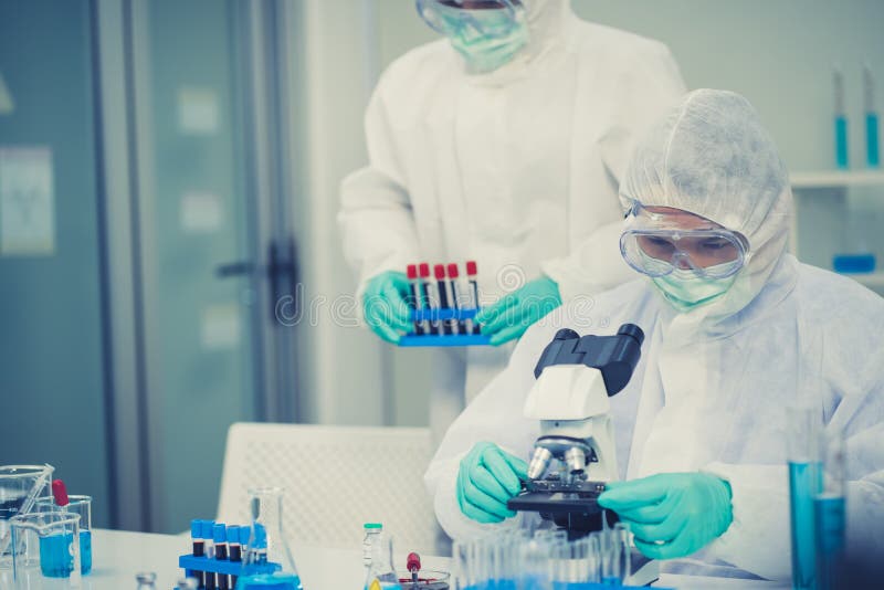 Group of Scientists with a Microscope in Laboratory, Developing a ...
