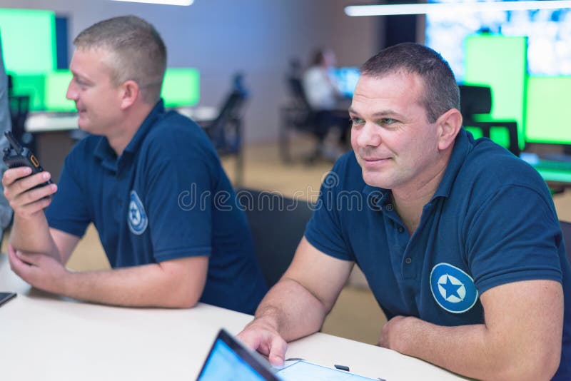 Group of Security Guards Working on Computers while Sitting in the Main ...