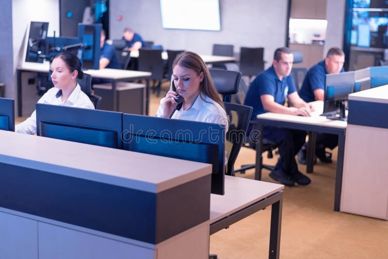 Group of Security Guards Working on Computers while Sitting in the Main ...