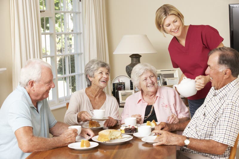 Group of Senior Couples Enjoying Afternoon Tea Together at Home with ...