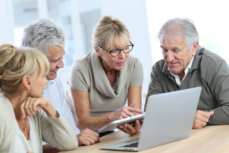 Group of Senior Friends Using Tablet and Laptop Stock Photo - Image of ...