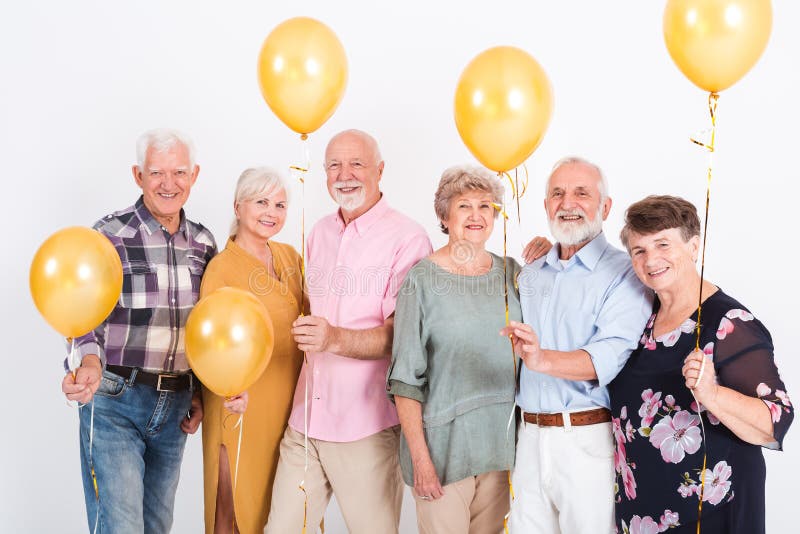 Senior People with Yellow Balloons Standing in Empty White Room Stock ...