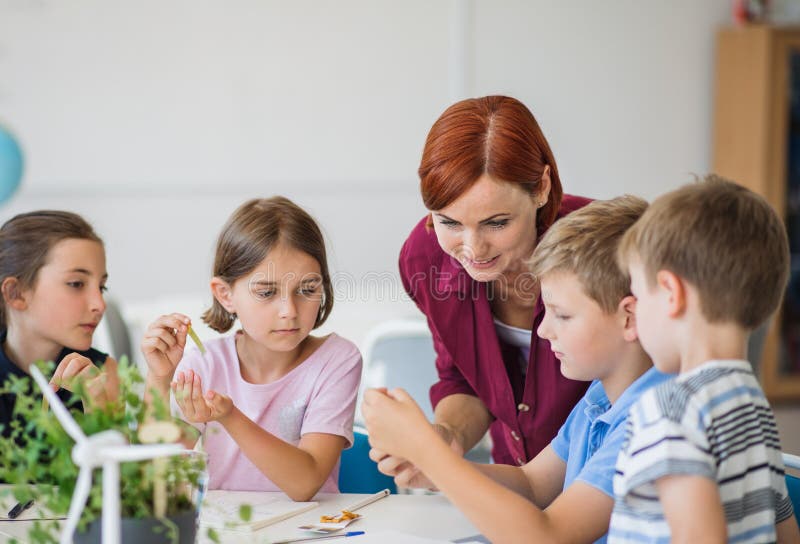 A Group of Small School Kids with Teacher in Class Learning about ...
