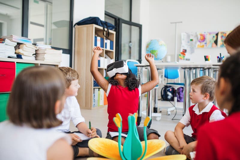 A Group of Small School Kids with VR Goggles Sitting on the Floor in ...