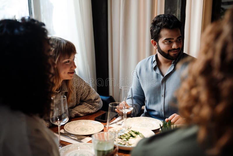 Group of Smiling Friends Talking while Dining in Restaurant Stock Photo ...