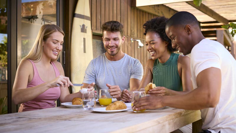 Group of Smiling Multi-Cultural Friends Eating Breakfast Outdoors at ...