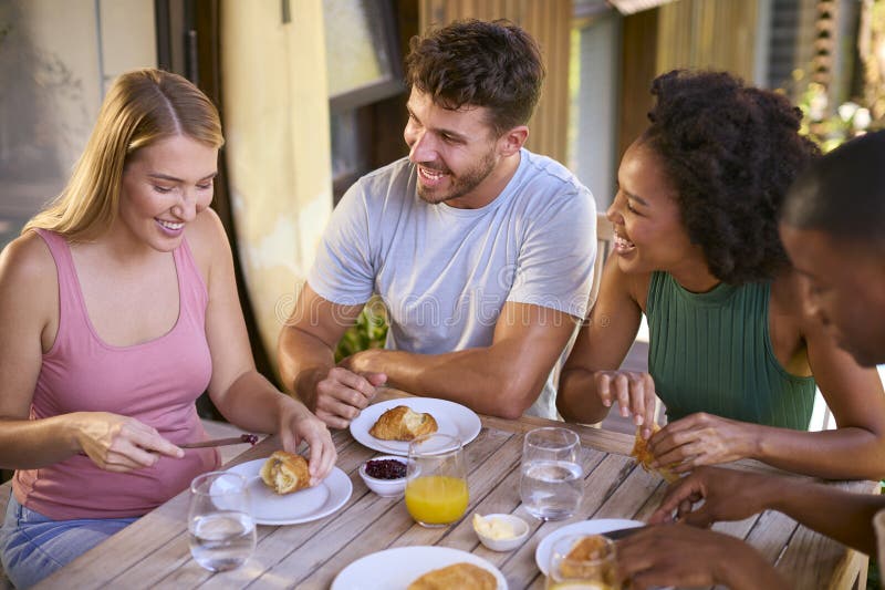 Group of Smiling Multi-Cultural Friends Eating Breakfast Outdoors at ...